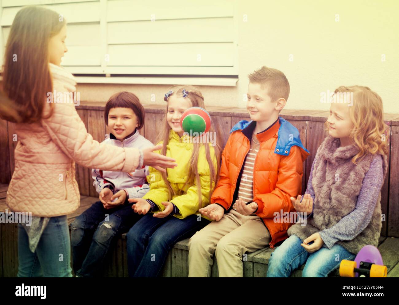Laughing children playing with Ball on wooden platform Stock Photo - Alamy