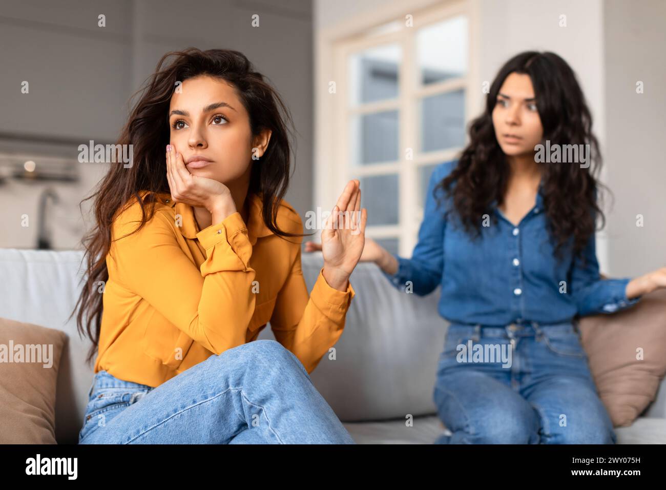 Two women having a disagreement on a couch Stock Photo - Alamy