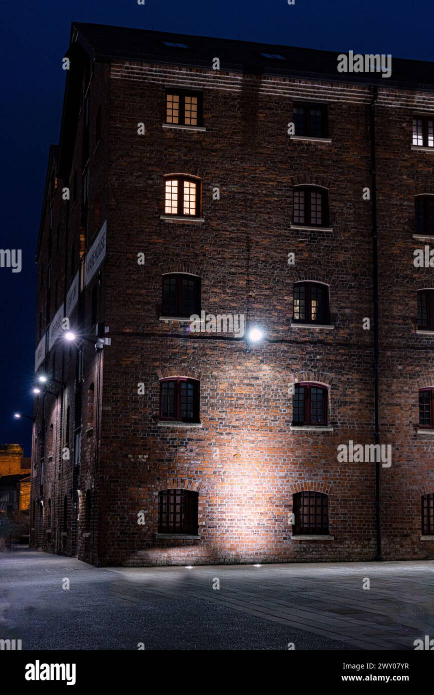 Illuminated Victorian red brick warehouse at the historic docks at ...