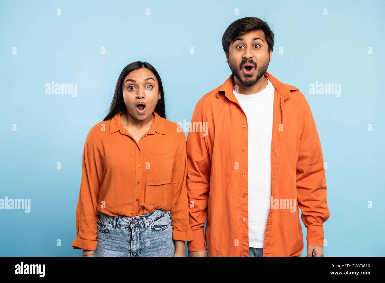 Couple showing surprise and excitement on blue Stock Photo - Alamy