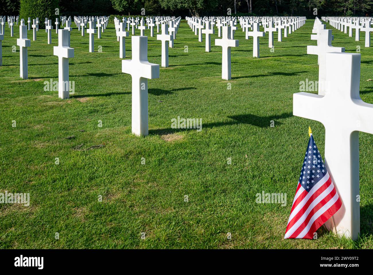 An American flag stands at the gravestone of a killed soldier at the ...