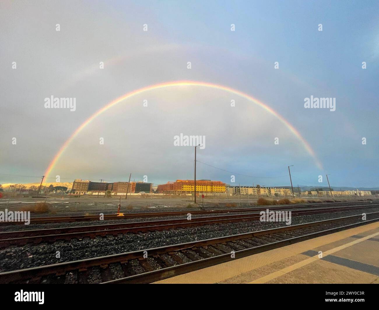 Rainbow over train tracks creating a stunning contrast Stock Photo - Alamy