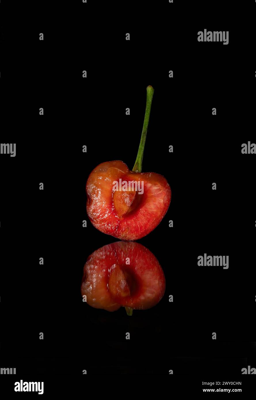 Cherry sliced in half with black background Stock Photo - Alamy