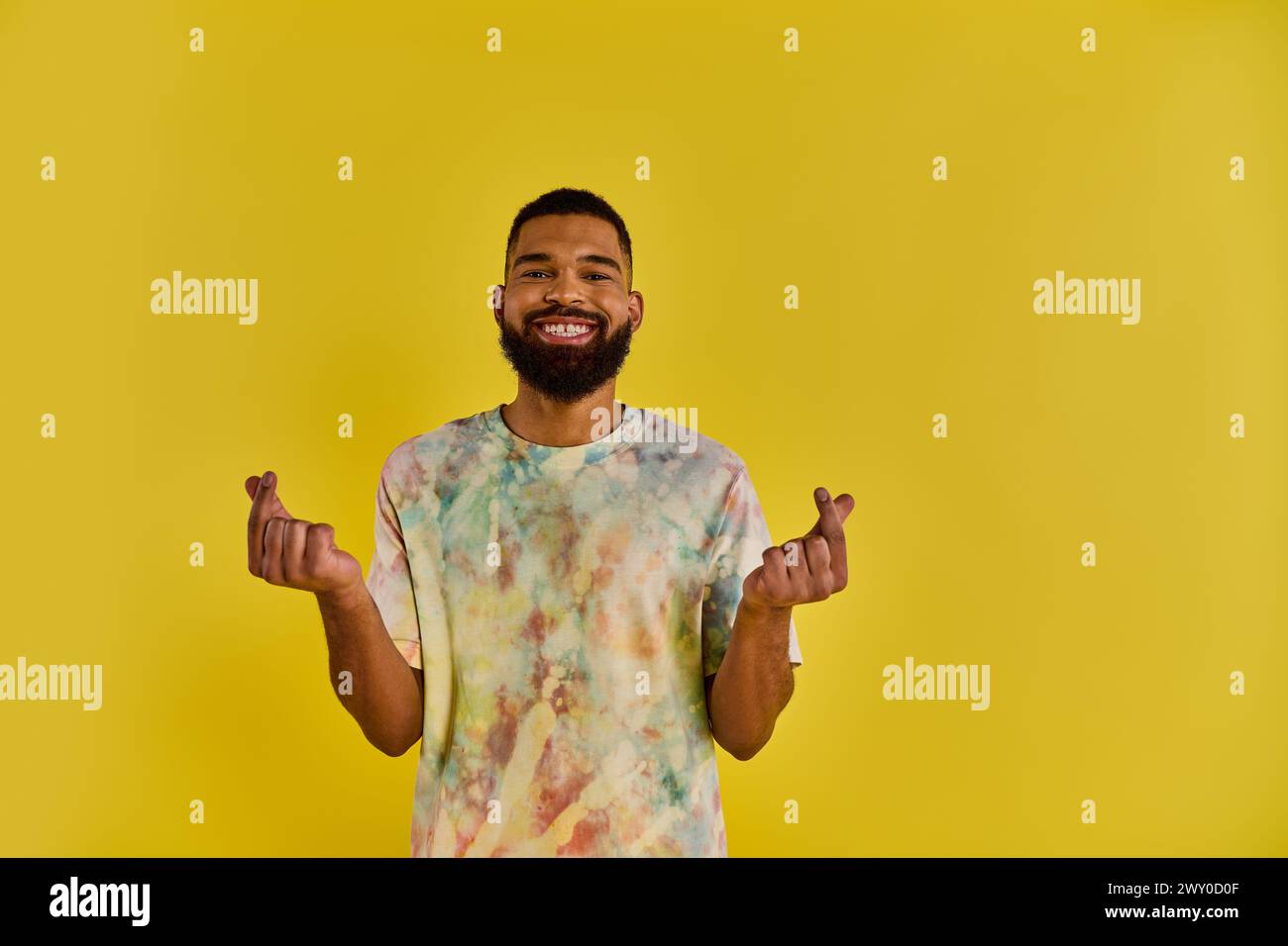 A lone man stands stoically in front of a vibrant yellow background ...