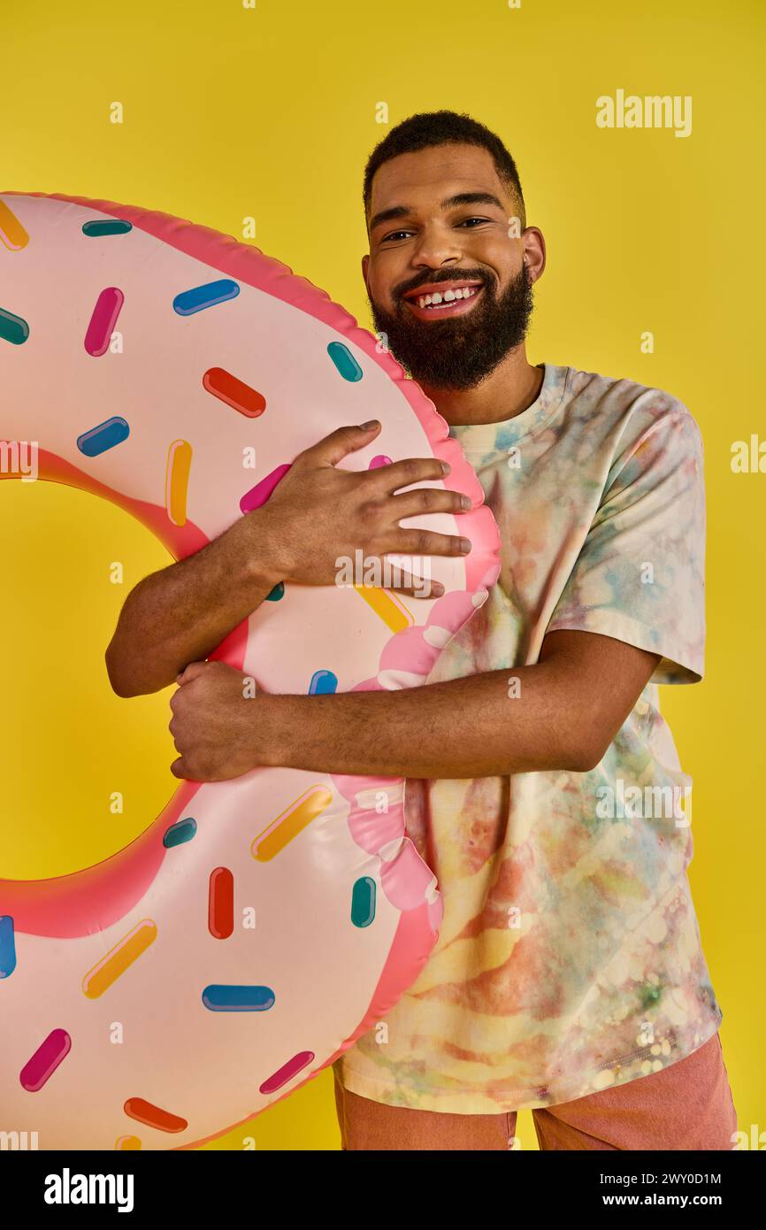 A man of unknown age is holding a colossal, delicious-looking donut in ...