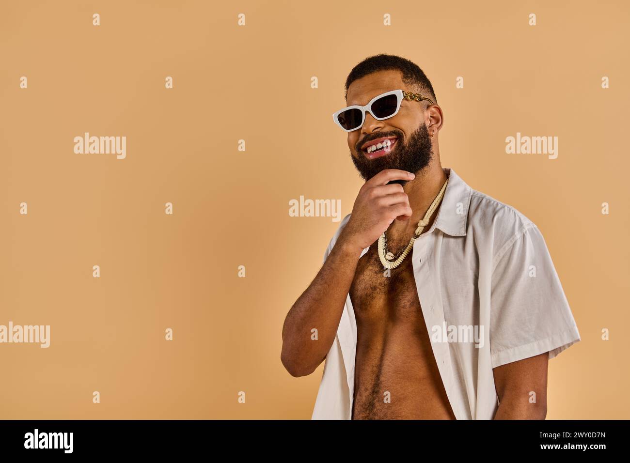 A man with a confident demeanor is wearing sunglasses and a fashionable ...