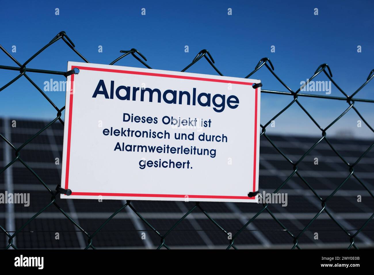 Hinweis auf Sicherung durch eine Alarmanlage am Zaun einer Solaranlage ...