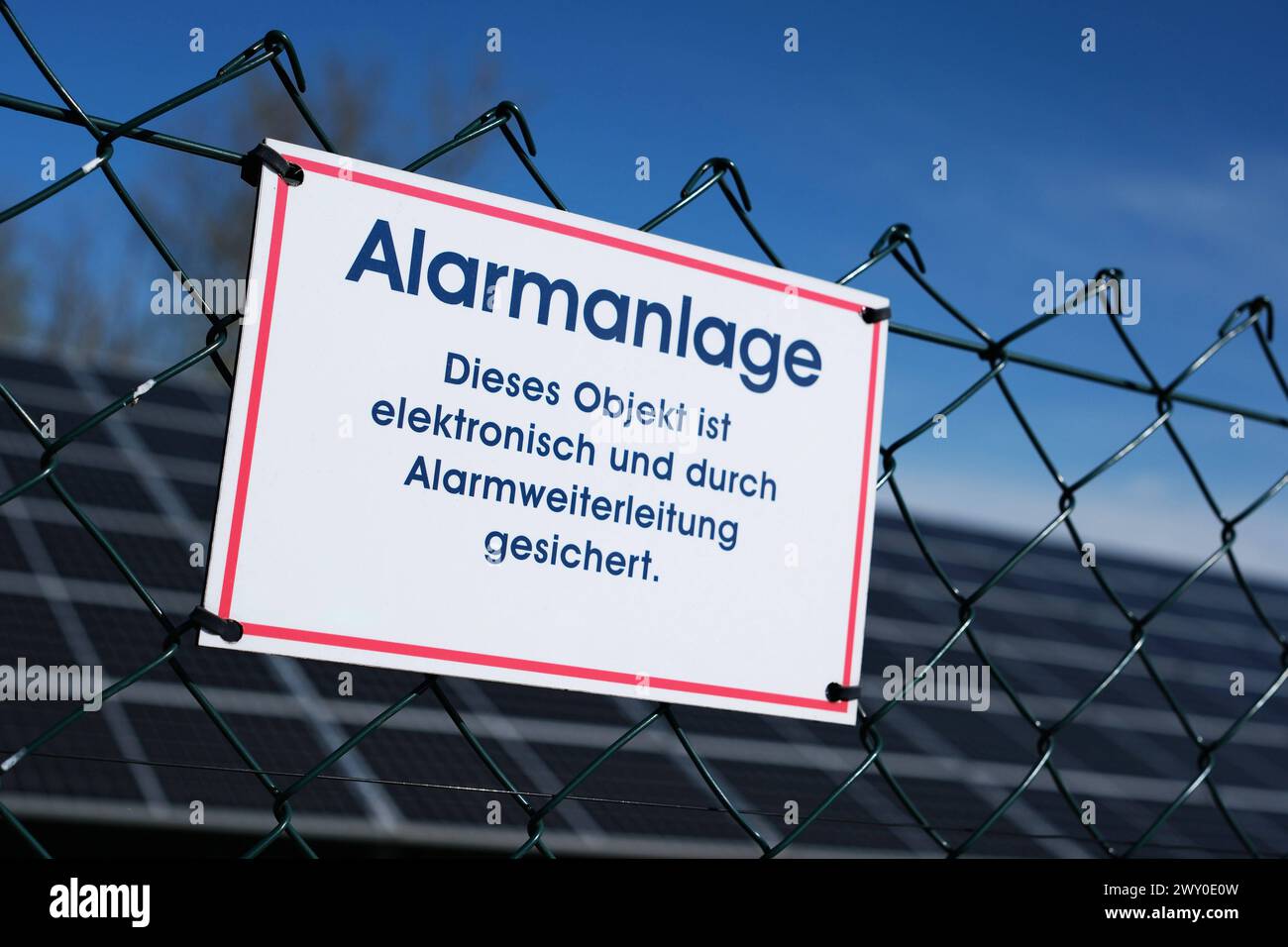 Hinweis auf Sicherung durch eine Alarmanlage am Zaun einer Solaranlage ...