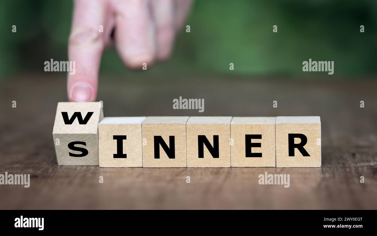 Hand turns dice and changes the word sinner to winner. Symbol for stop ...