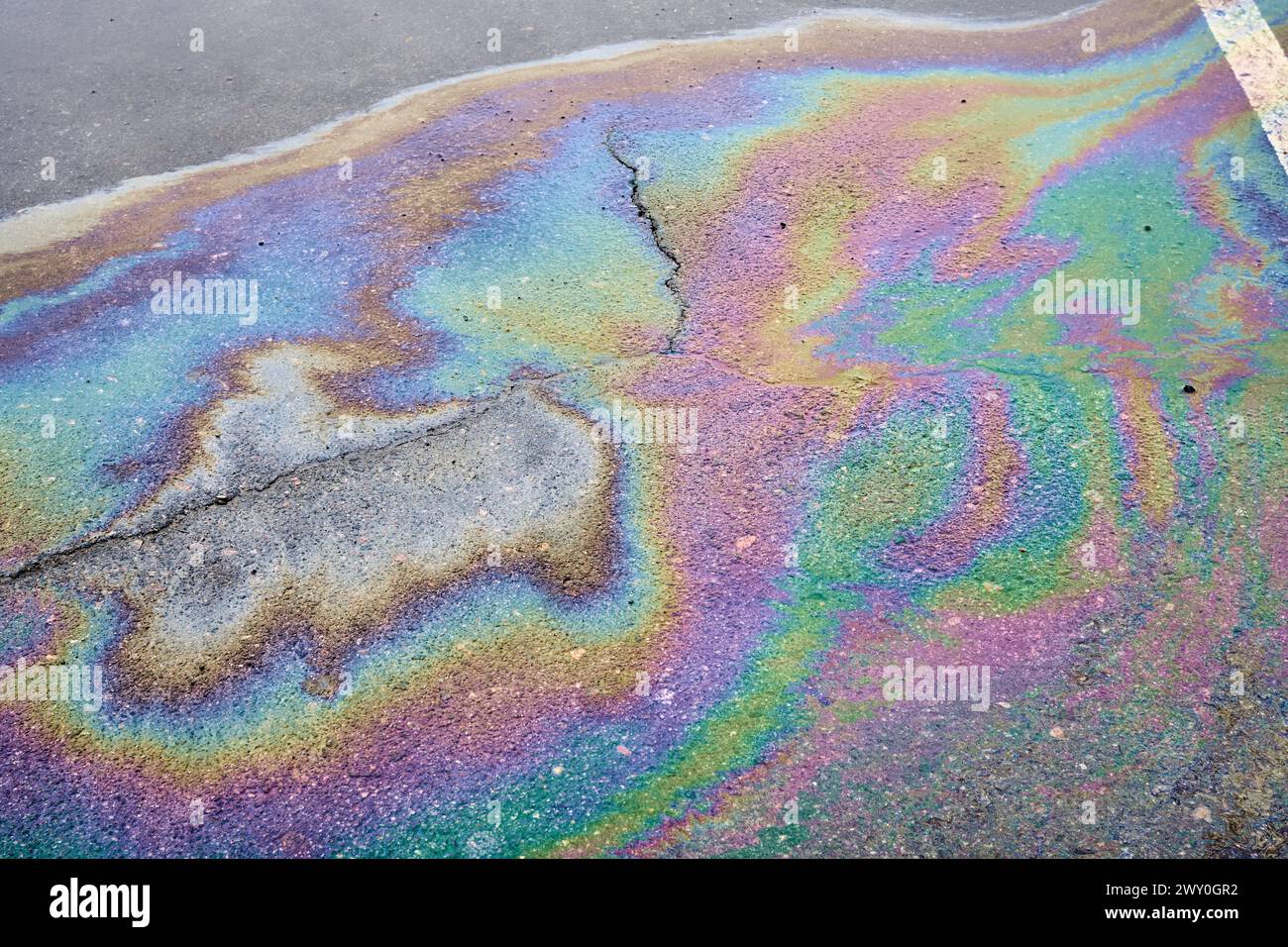 Oil stains from leaks in the car engine. Oil after rain makes spots ...