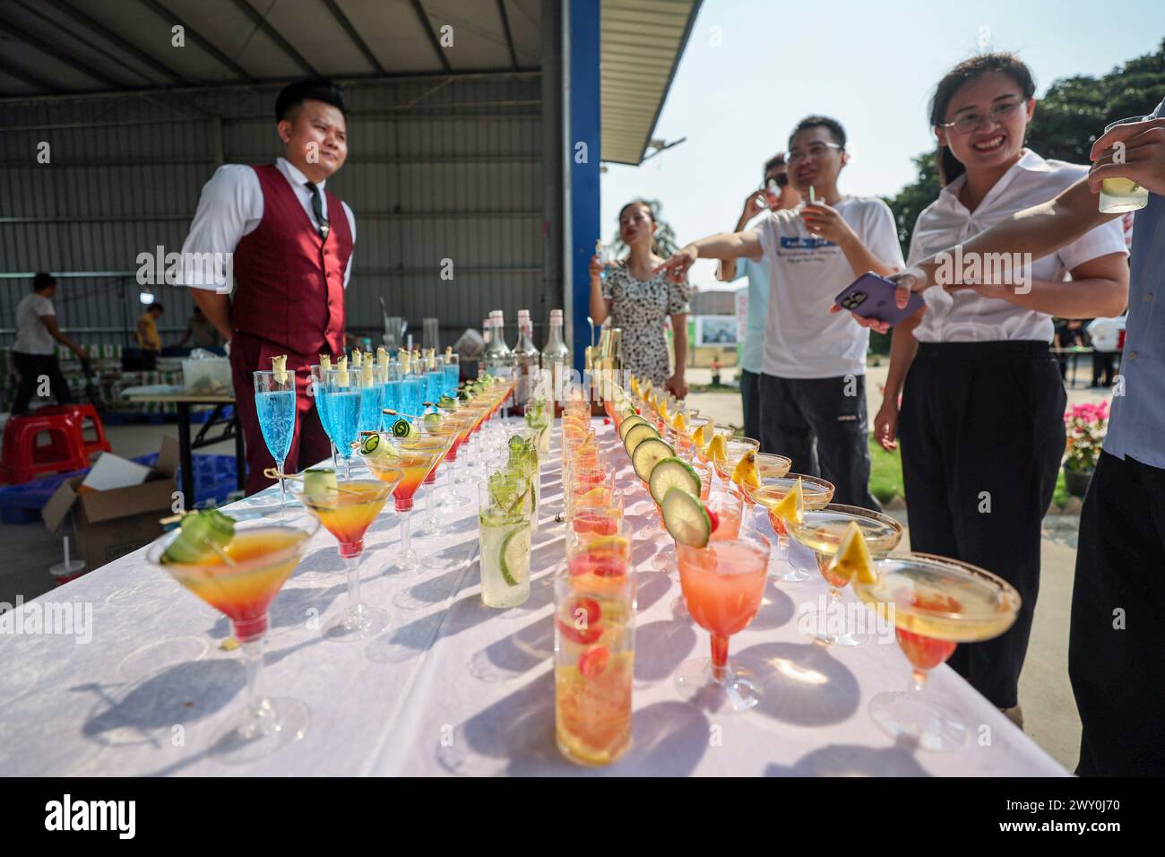 Dingan, China's Hainan Province. 3rd Apr, 2024. Tourists taste drinks ...