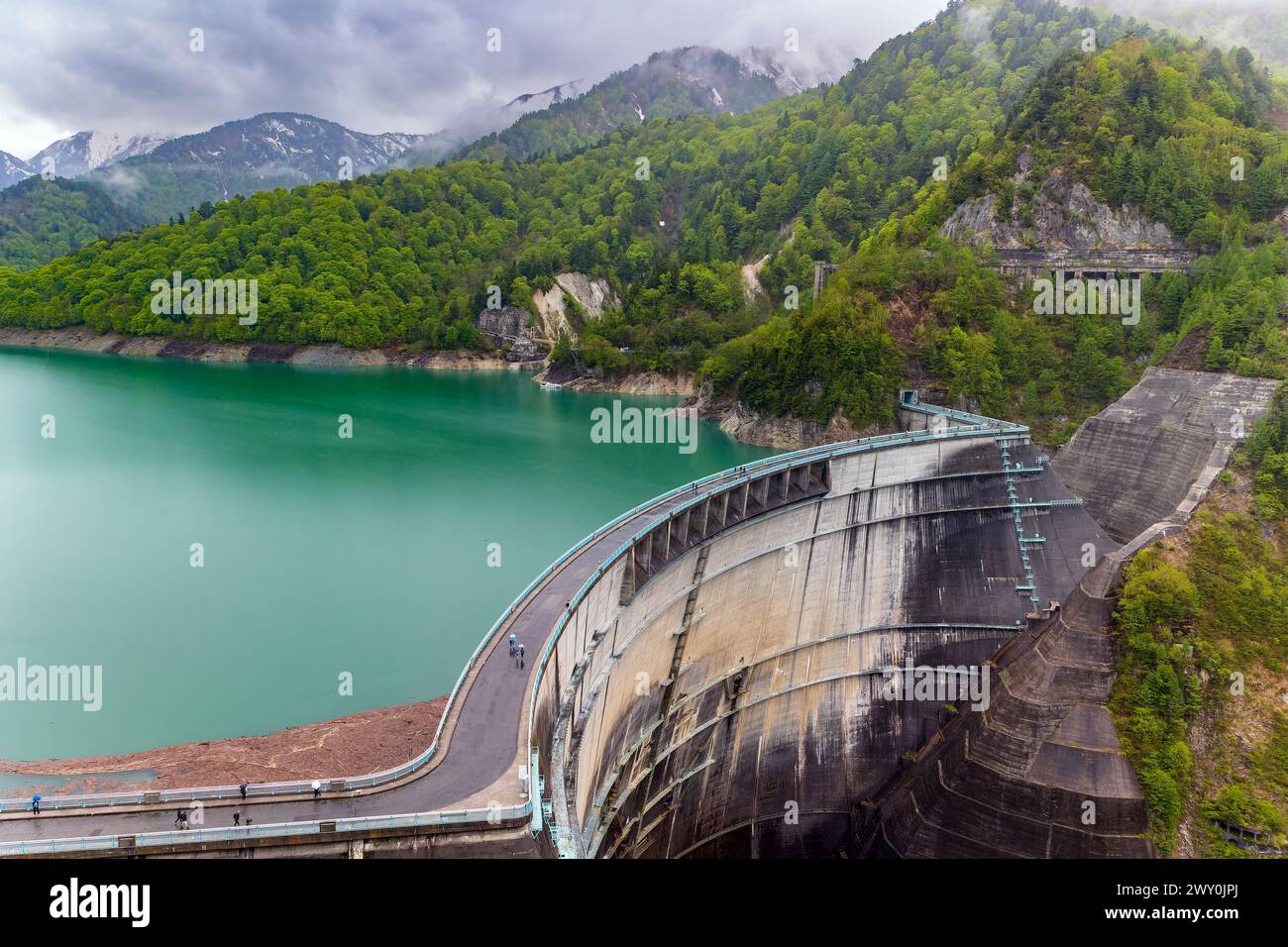 Stormy skies and snowcapped mountains next to a huge hydroelectric dam ...