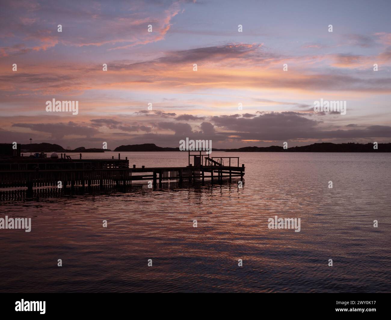 The tranquil sunset reflects on the calm water and dock Stock Photo - Alamy