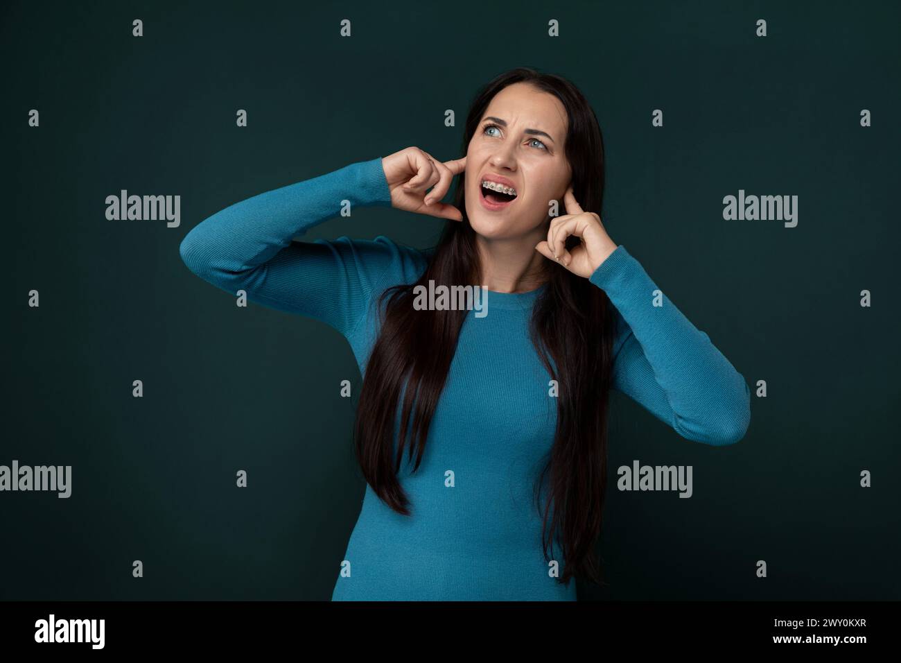 Woman in Blue Shirt Holding Hands to Ears Stock Photo - Alamy
