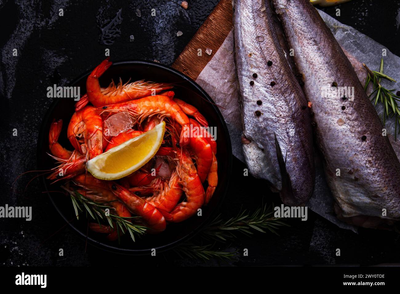Assorted uncooked seafood, prawns and hake fish with lemon and herbs ...