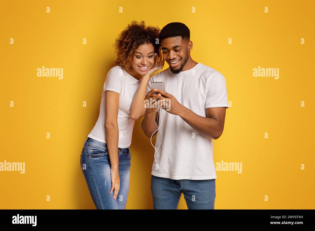Couple sharing earbuds hi-res stock photography and images - Alamy