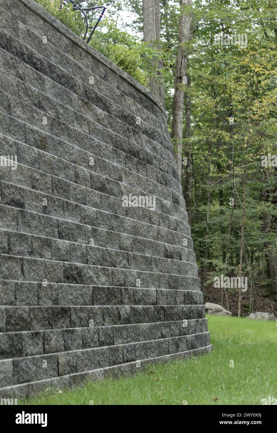 tall stone retaining wall (curved brick masonry) in house back yard ...