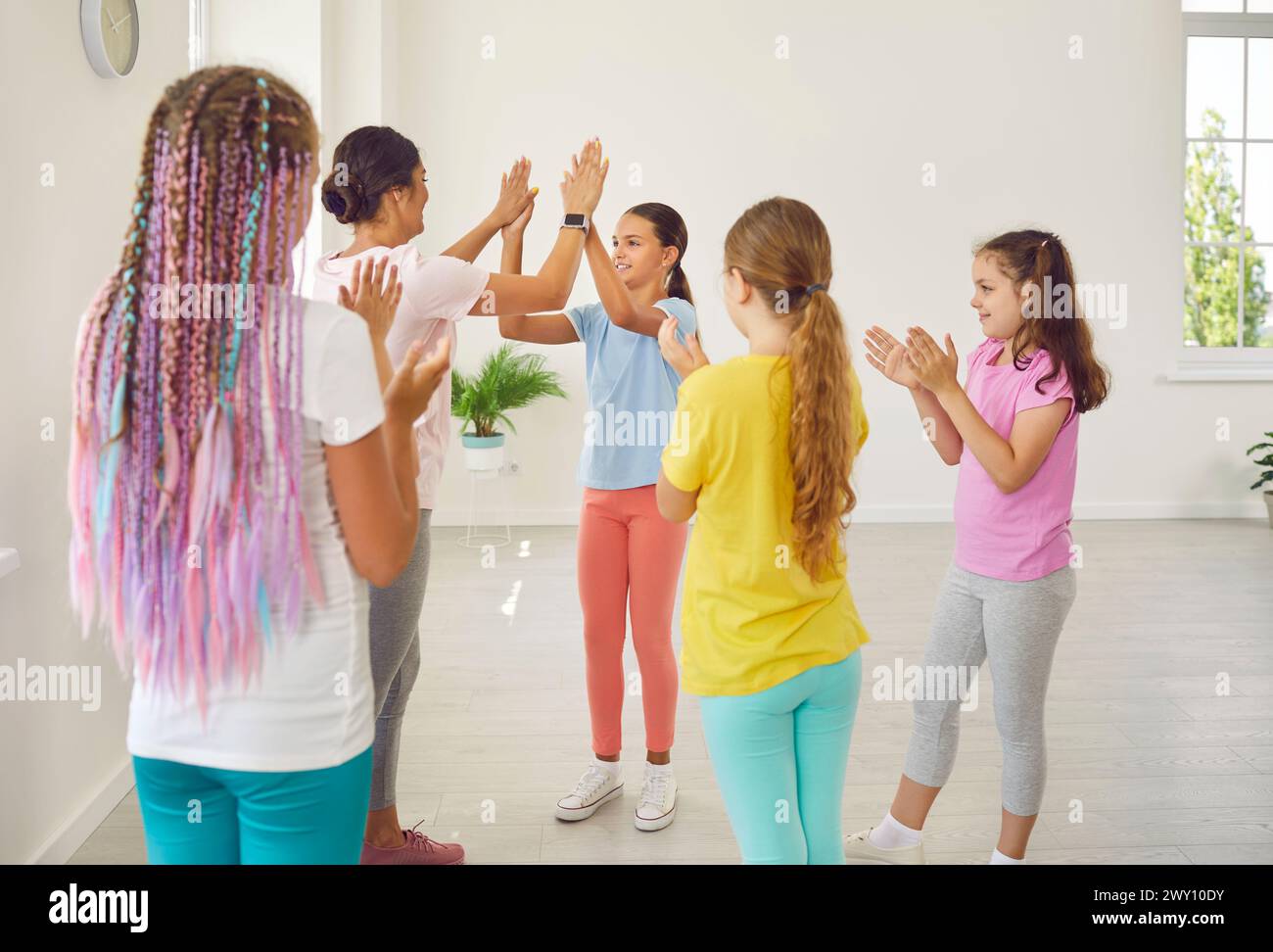 Female friendly choreographer or sport trainer giving high five to ...