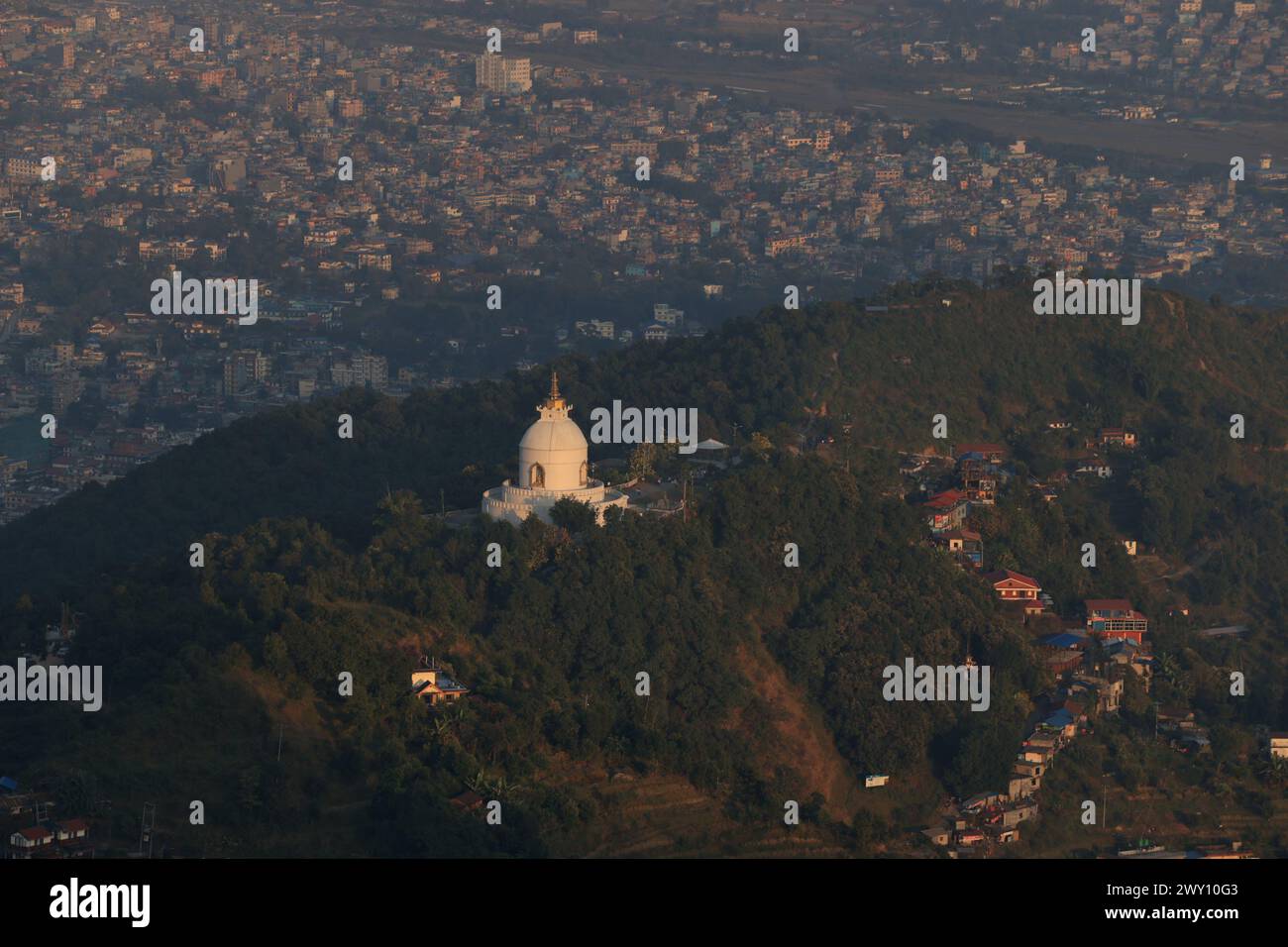 the outlook of Peace Pagoda in hill area with the townscape of Pokhara ...