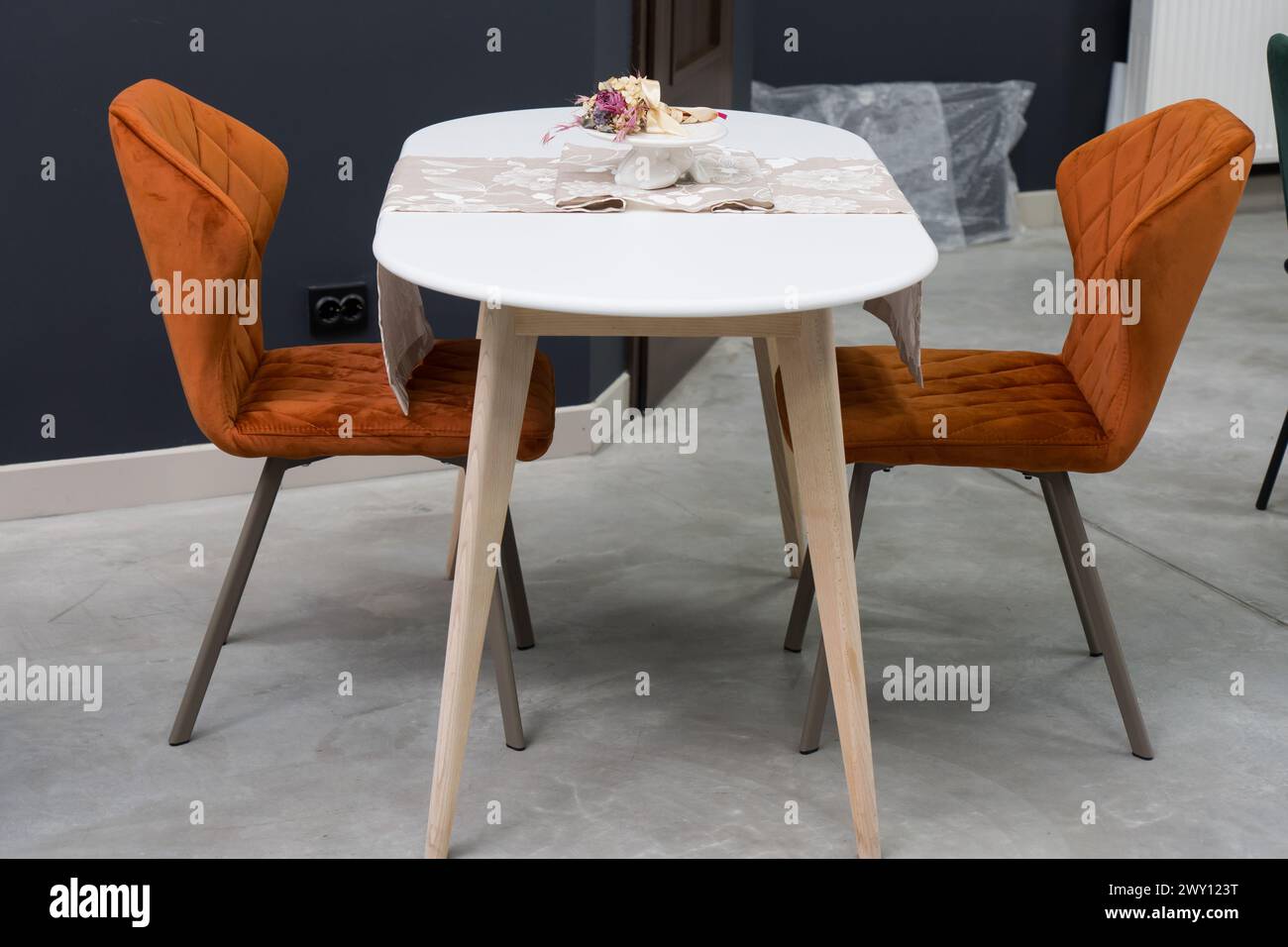White wooden table combined with orange chairs with soft fabric ...
