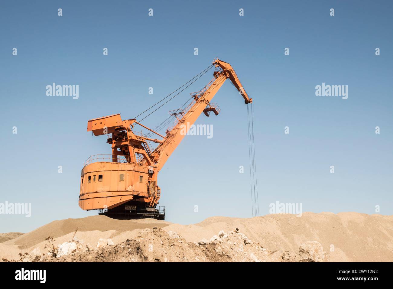 Port industrial cranes at river sand unloading depot on clear sunny day ...