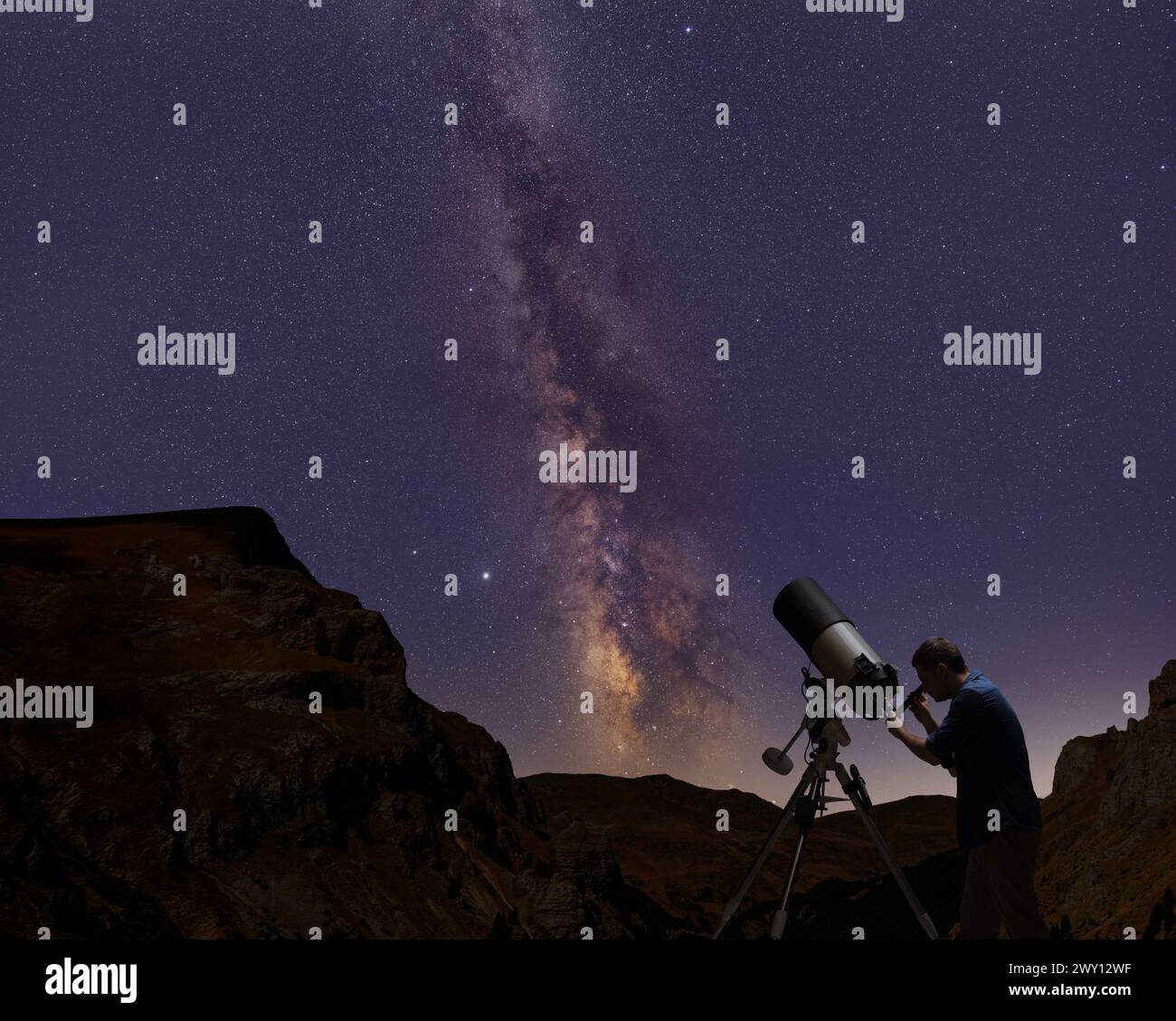 Man using a telescope and observing stars and the milky way on a night ...