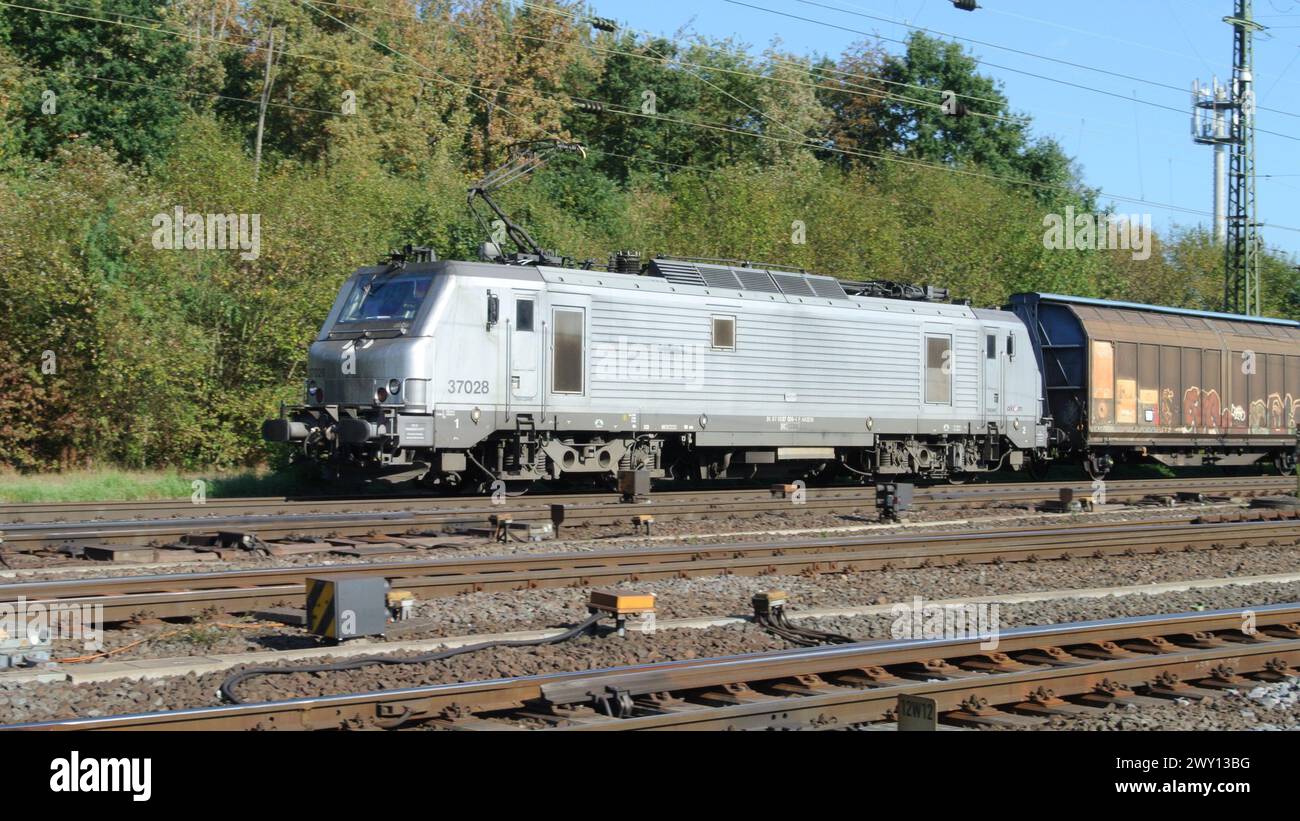 Akiem 37028 electric powered locomotive with cargo wagon at Cologne ...