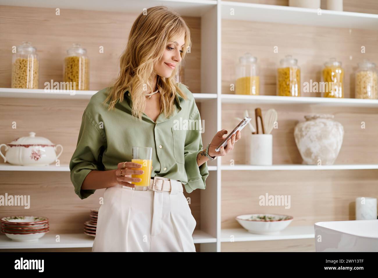 Woman standing in kitchen holding hi-res stock photography and images ...