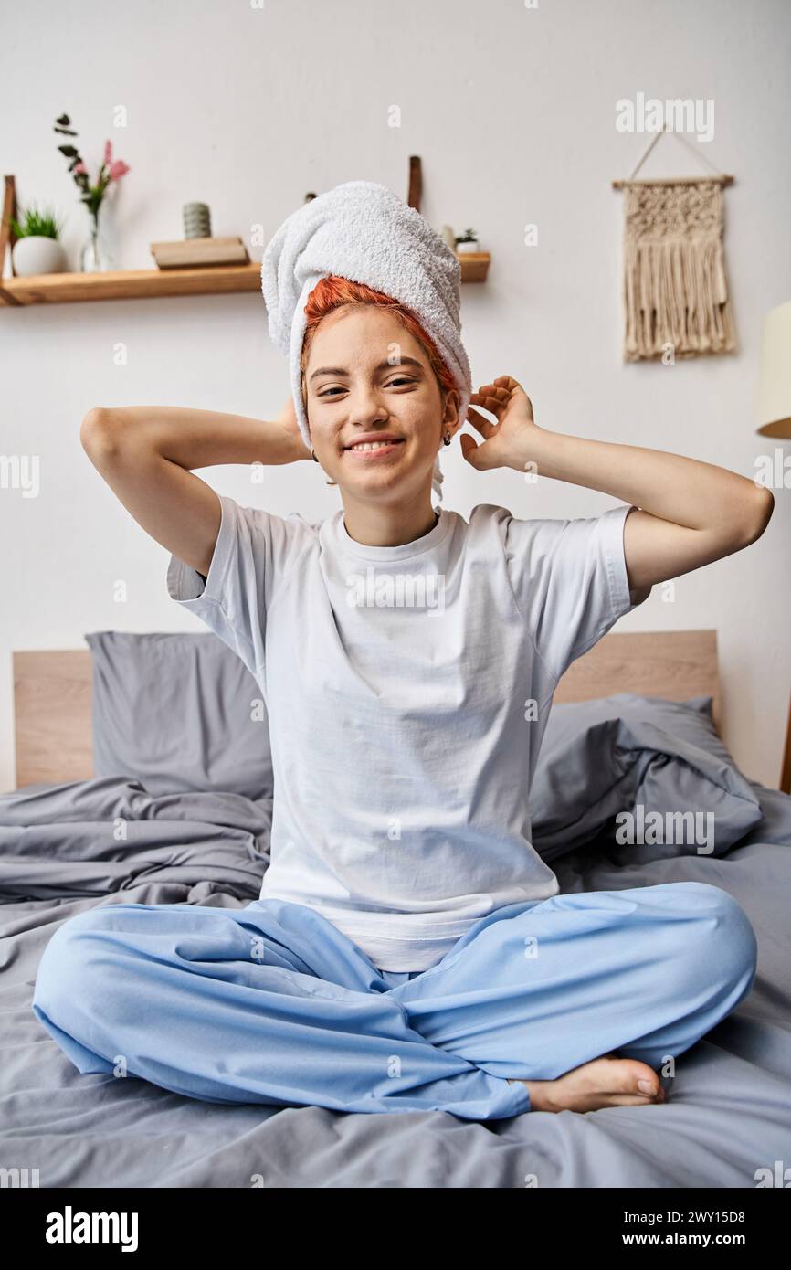 beautiful positive queer person in homewear with hair towel looking at ...