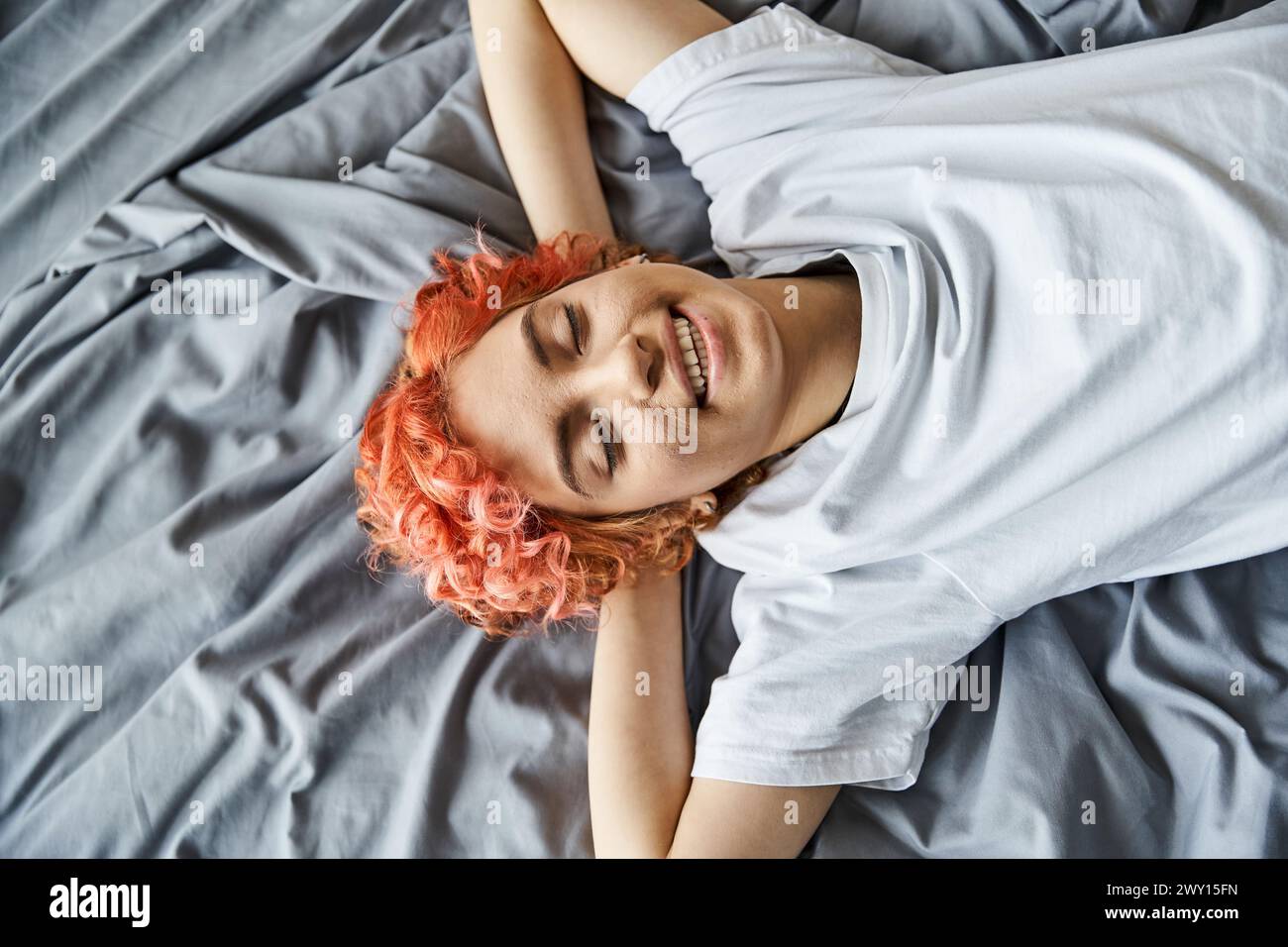 Good Looking Jolly Queer Person In Cozy Homewear Relaxing On Her Bed