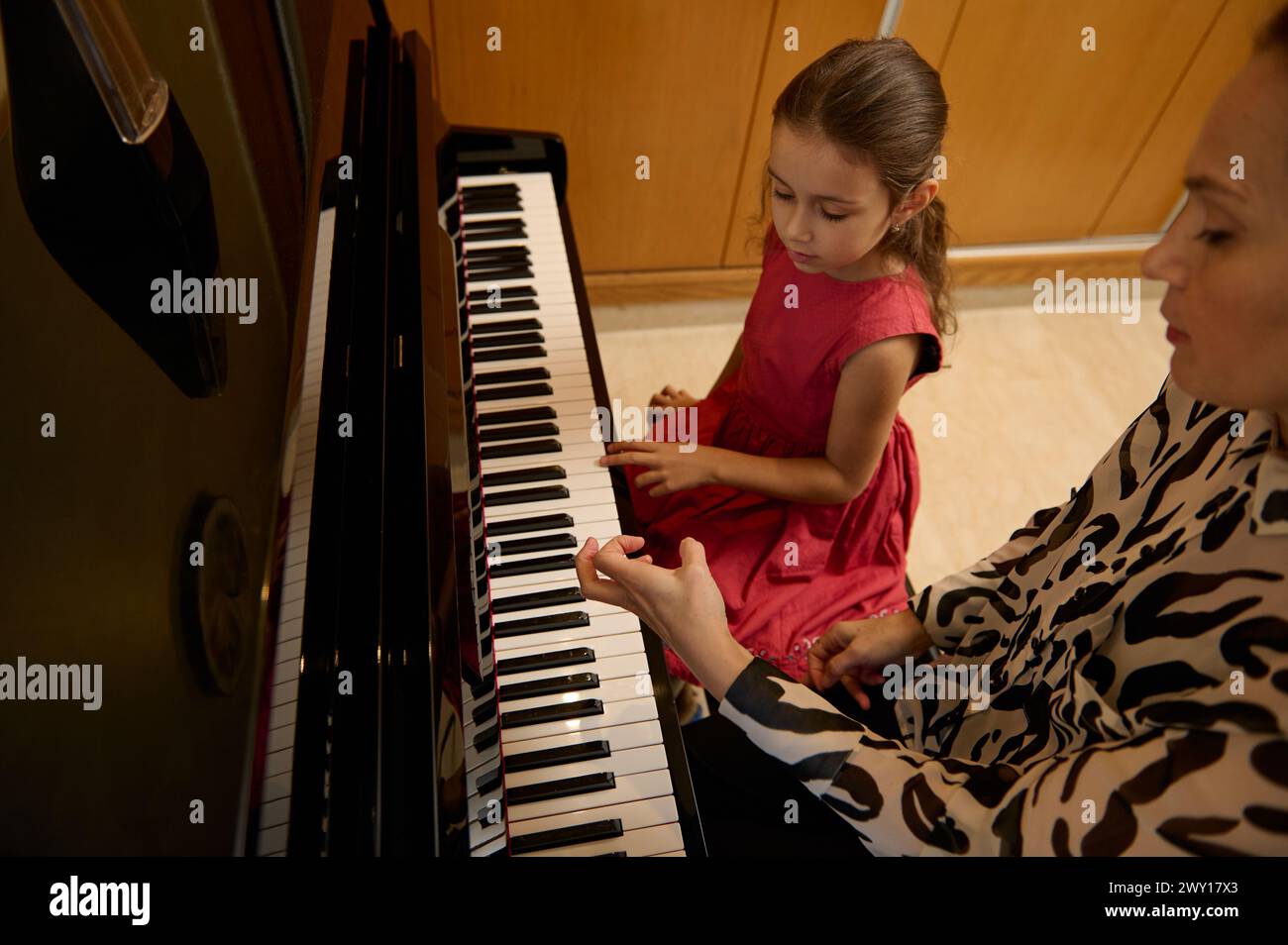 Little child girl having a piano lesson with her teacher. Female ...