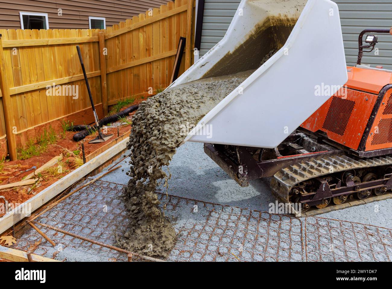 Wet cement is poured into framework using self dumping track concrete ...