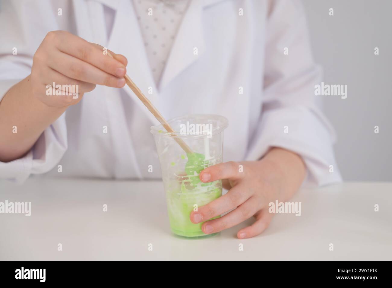 Faceless girl doing chemical experiments on a white background. Making ...