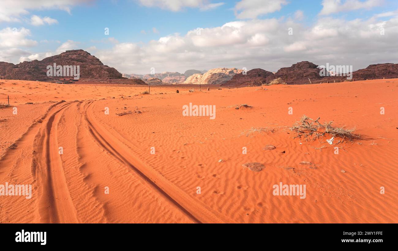 Rocky massifs on red orange sand desert, vehicle tracks ground, bright ...