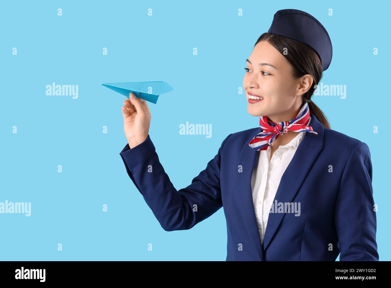 Beautiful Asian stewardess with paper plane on blue background Stock ...