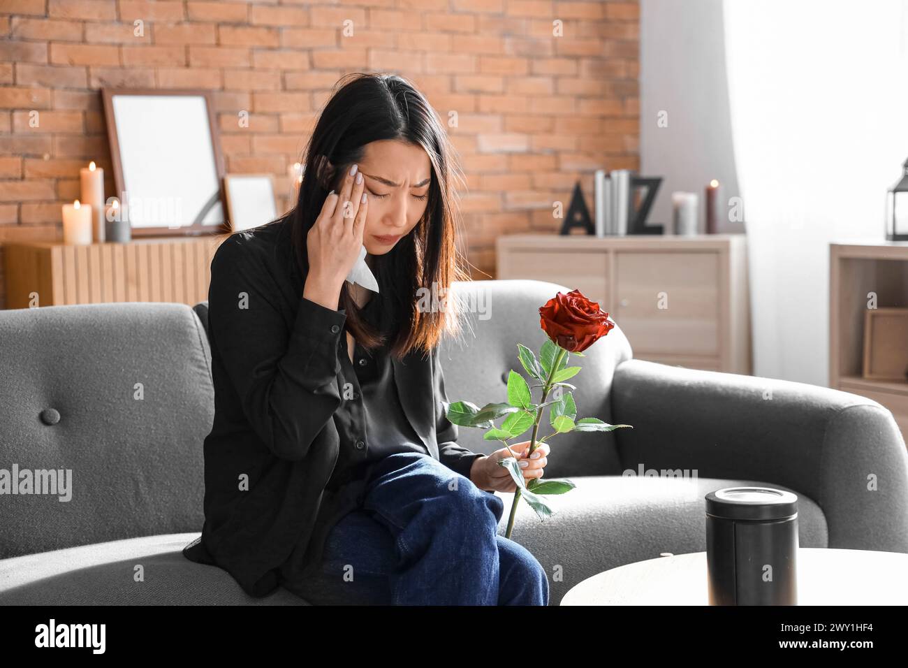 Grieving young Asian woman with rose crying at funeral Stock Photo - Alamy