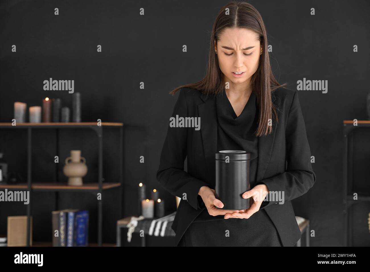 Grieving young woman with mortuary urn at funeral Stock Photo - Alamy