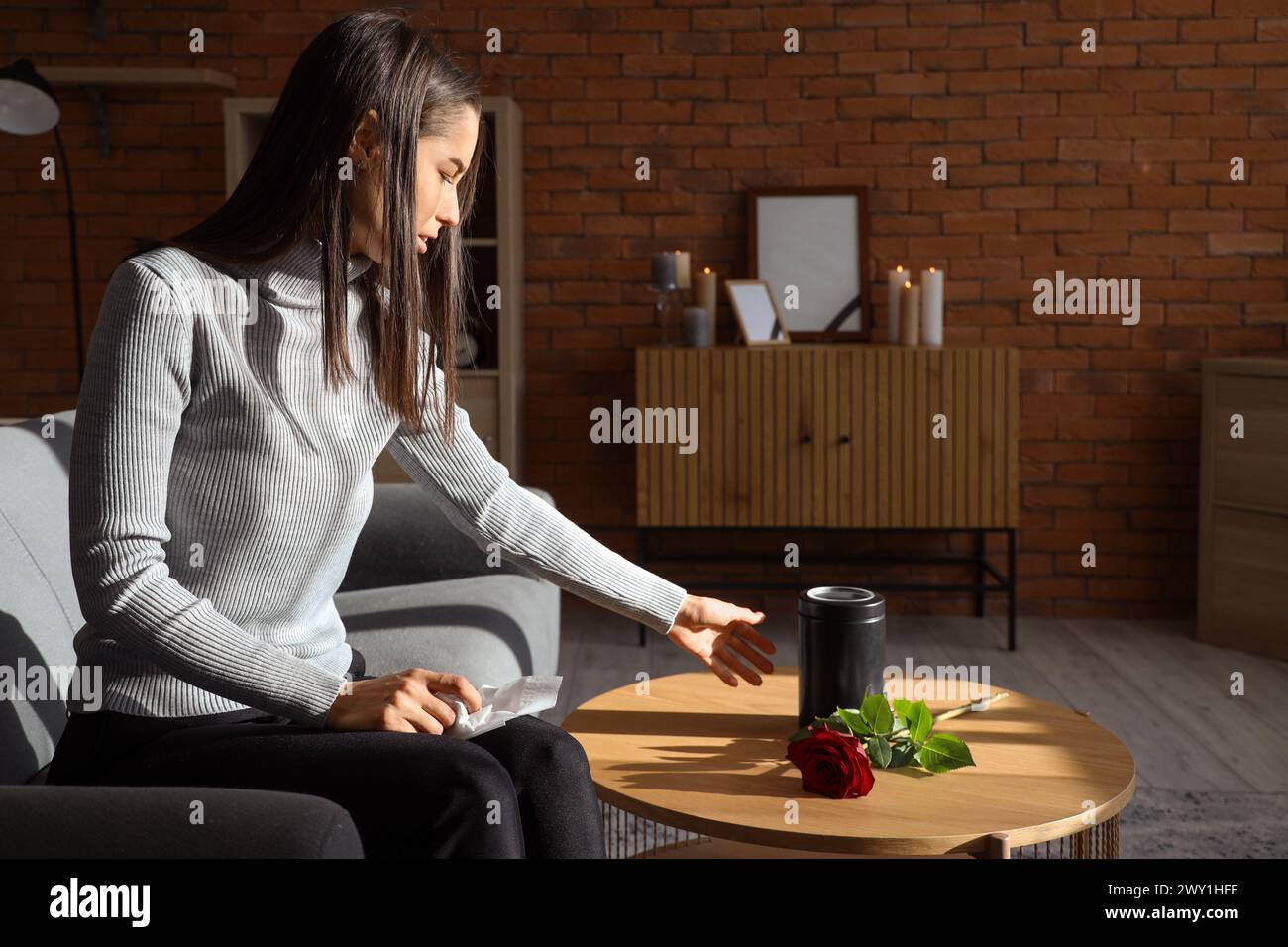 Mourning young woman with mortuary urn at funeral Stock Photo - Alamy