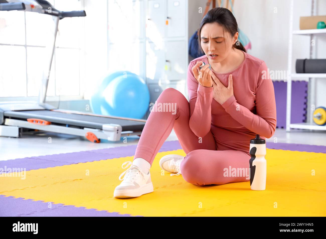 Sporty young woman with asthma attack using inhaler in gym Stock Photo ...