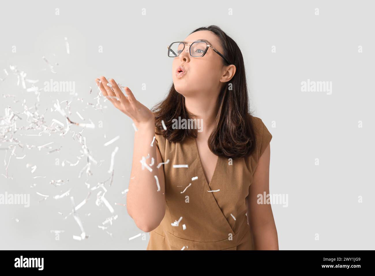 Secretary with shredded paper on light background Stock Photo - Alamy