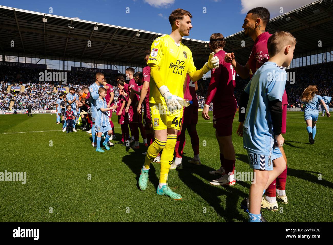 Players and matchday mascots shake hands on the pitch ahead of the Sky ...