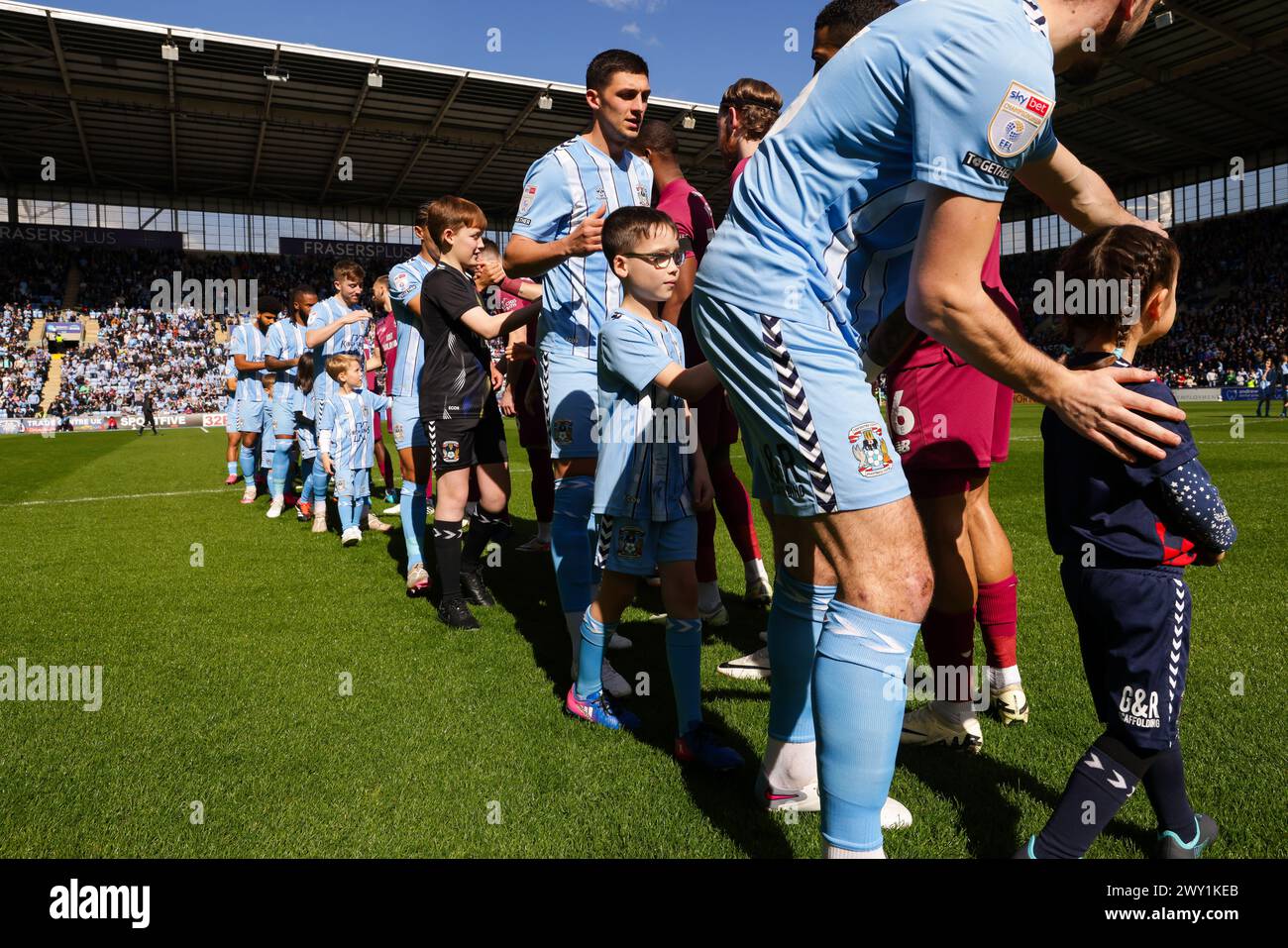 Players and matchday mascots shake hands on the pitch ahead of the Sky ...