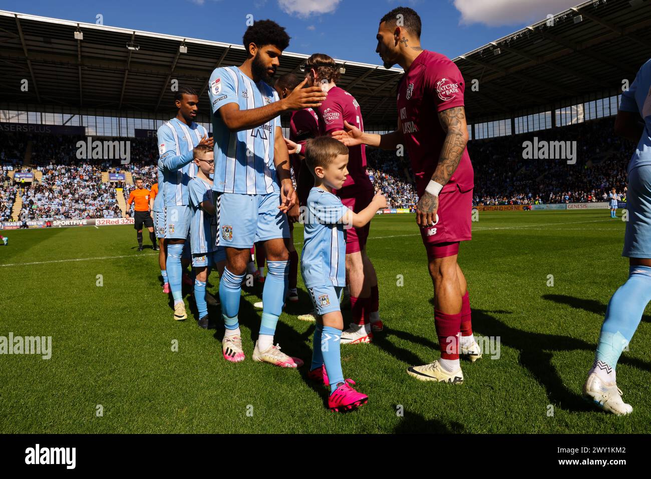 Players and matchday mascots shake hands on the pitch ahead of the Sky ...