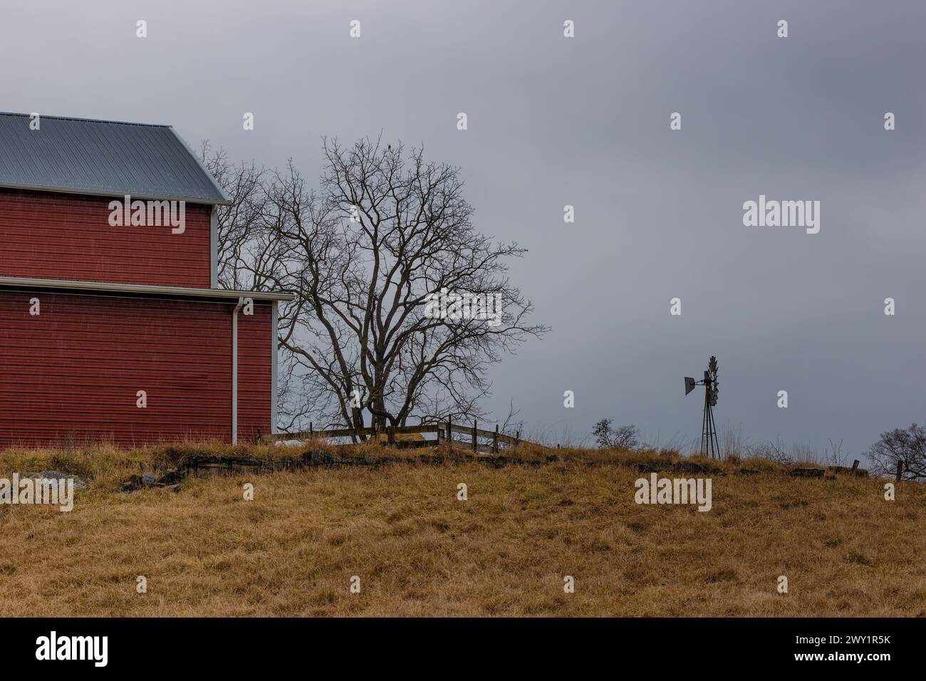 Agricultural landscape with barn on a hill and a windmill in this ...