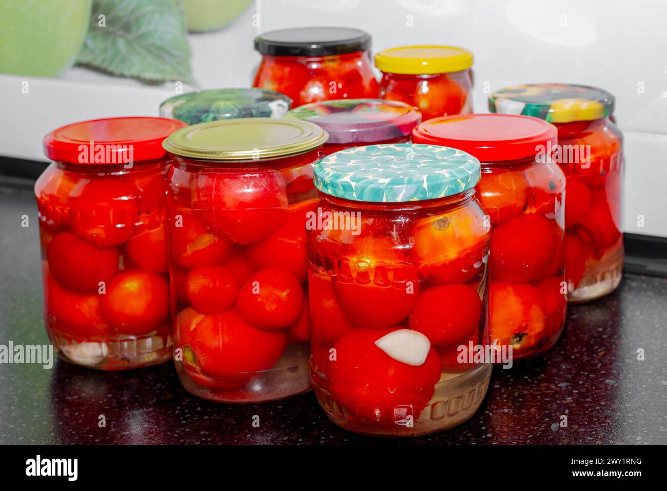 Glass jars with red tomatoes filled with brine. Preparations for the ...