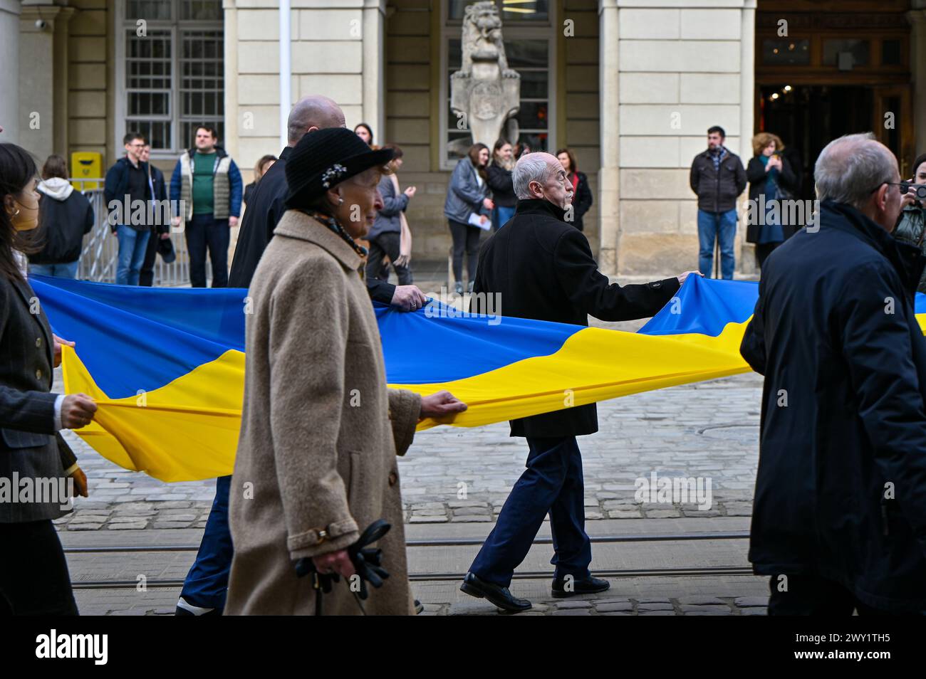 LVIV, UKRAINE - APRIL 3, 2024 - People carry a blue and yellow national ...