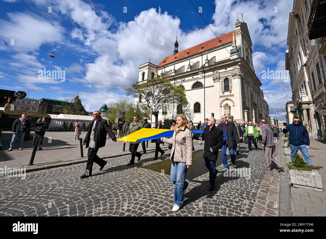 LVIV, UKRAINE - APRIL 3, 2024 - People carry a blue and yellow national ...