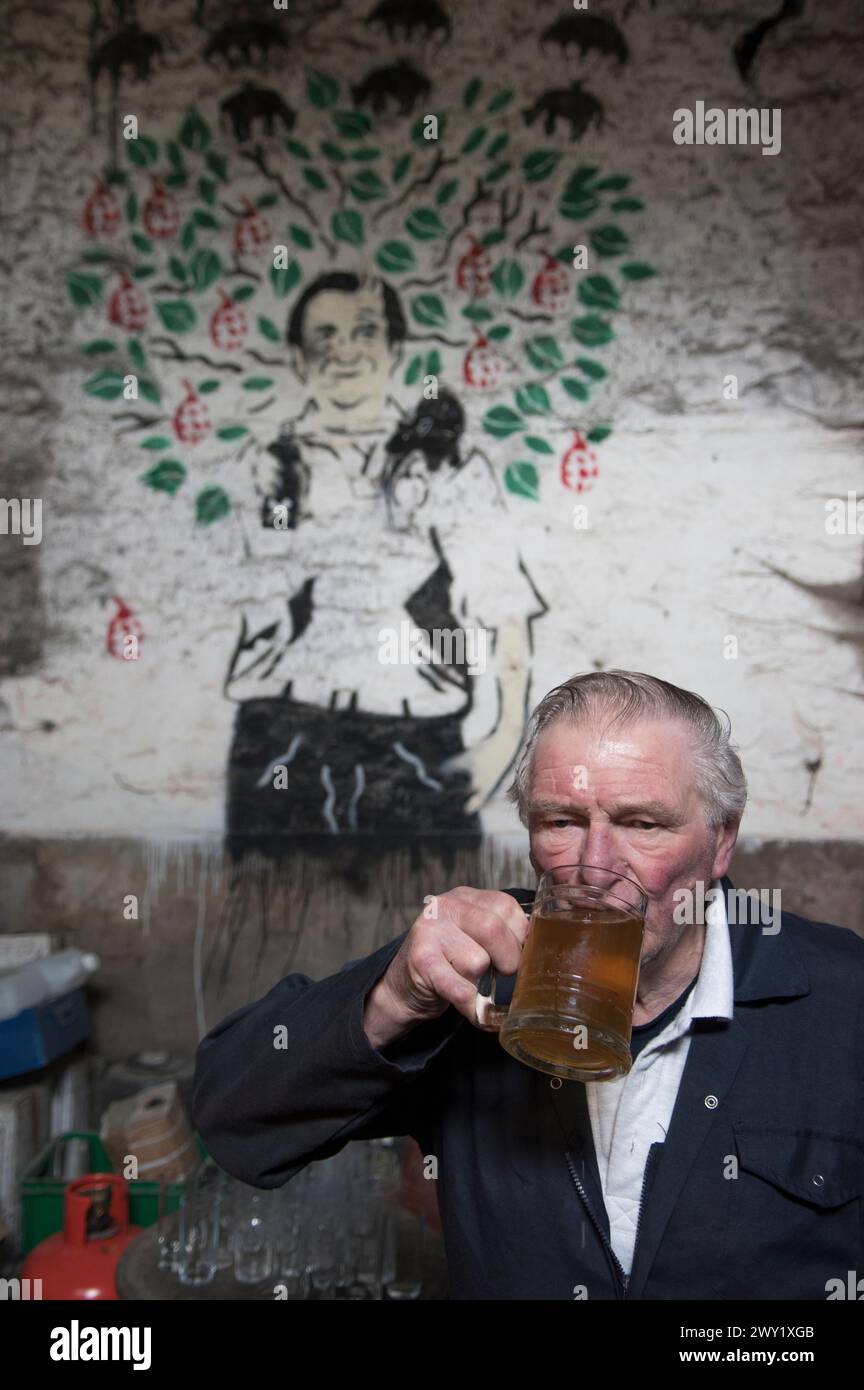 Roger Wilkins cider farmer standing in front of a Banksy portrait that ...