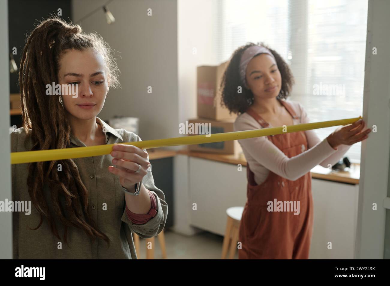 Female worker or designer with dreadlocks and her colleague holding ...