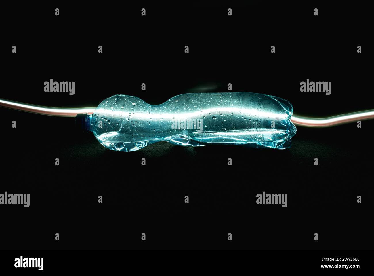 A crushed plastic bottle partially filled with water, lying ...